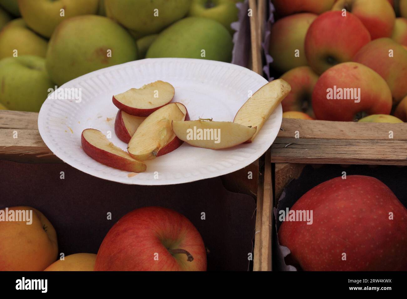 Tasting plate with apple slices, background fruit boxes with different ...