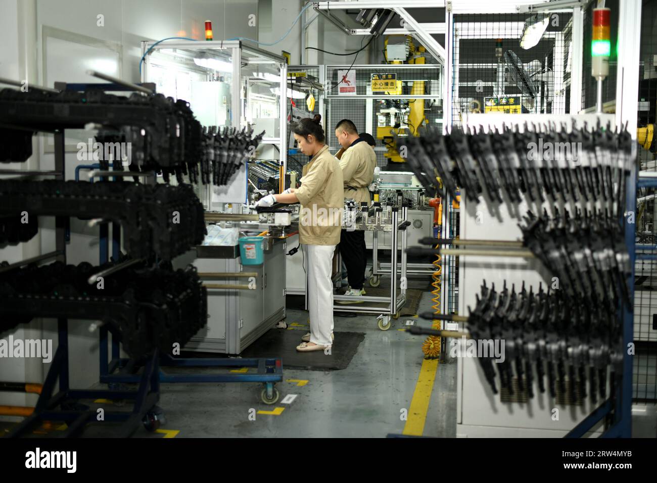 A worker produces sunroof glass for new energy vehicles on an ...