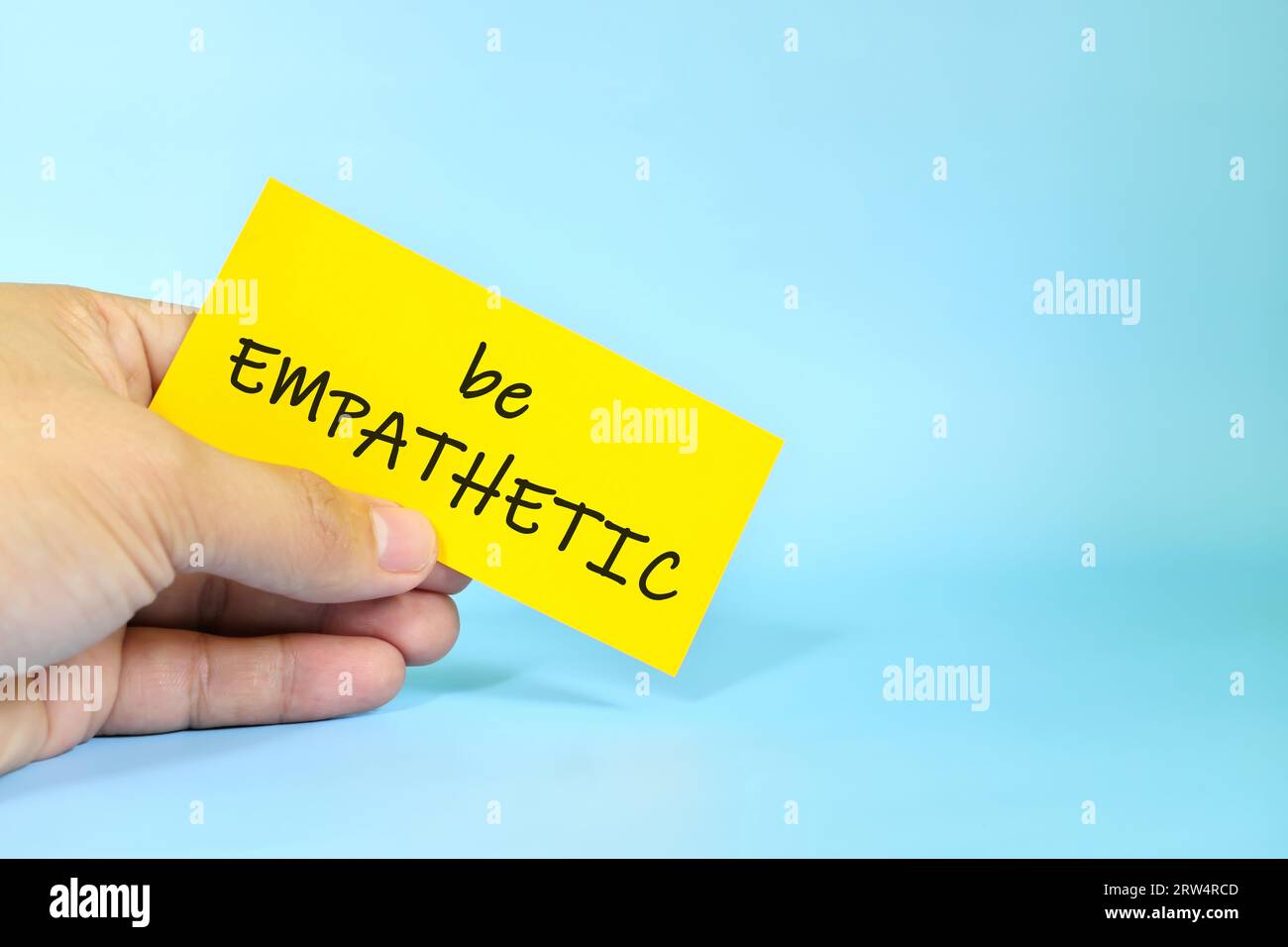Show empathy reminder concept. Hand holding a bright paper message note ...