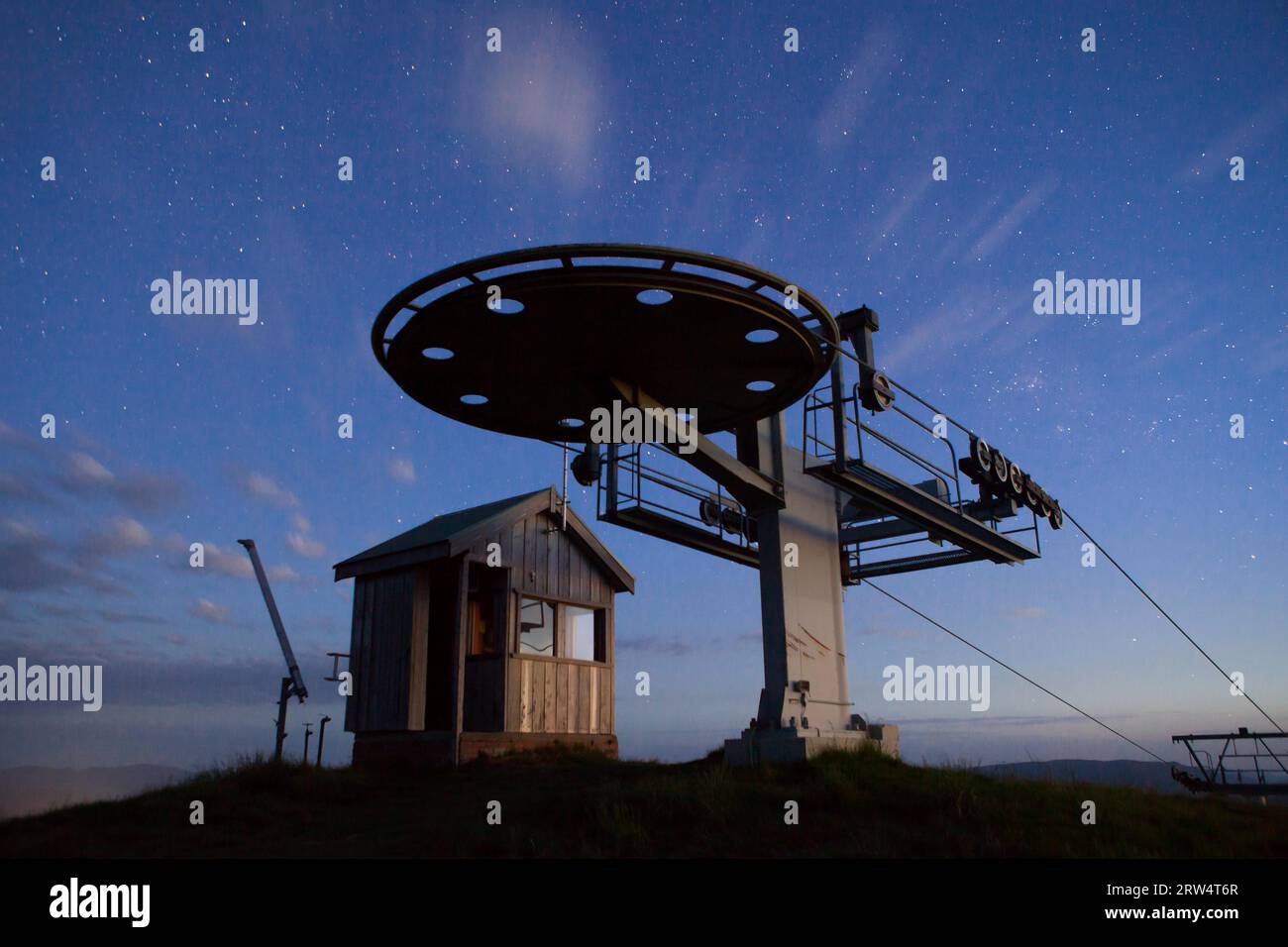 A lonesome ski lift and building under a summer starry sky at Mt Buller ...
