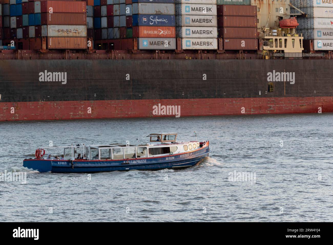 The barge Nordsee IV in front of a container ship with containers of ...