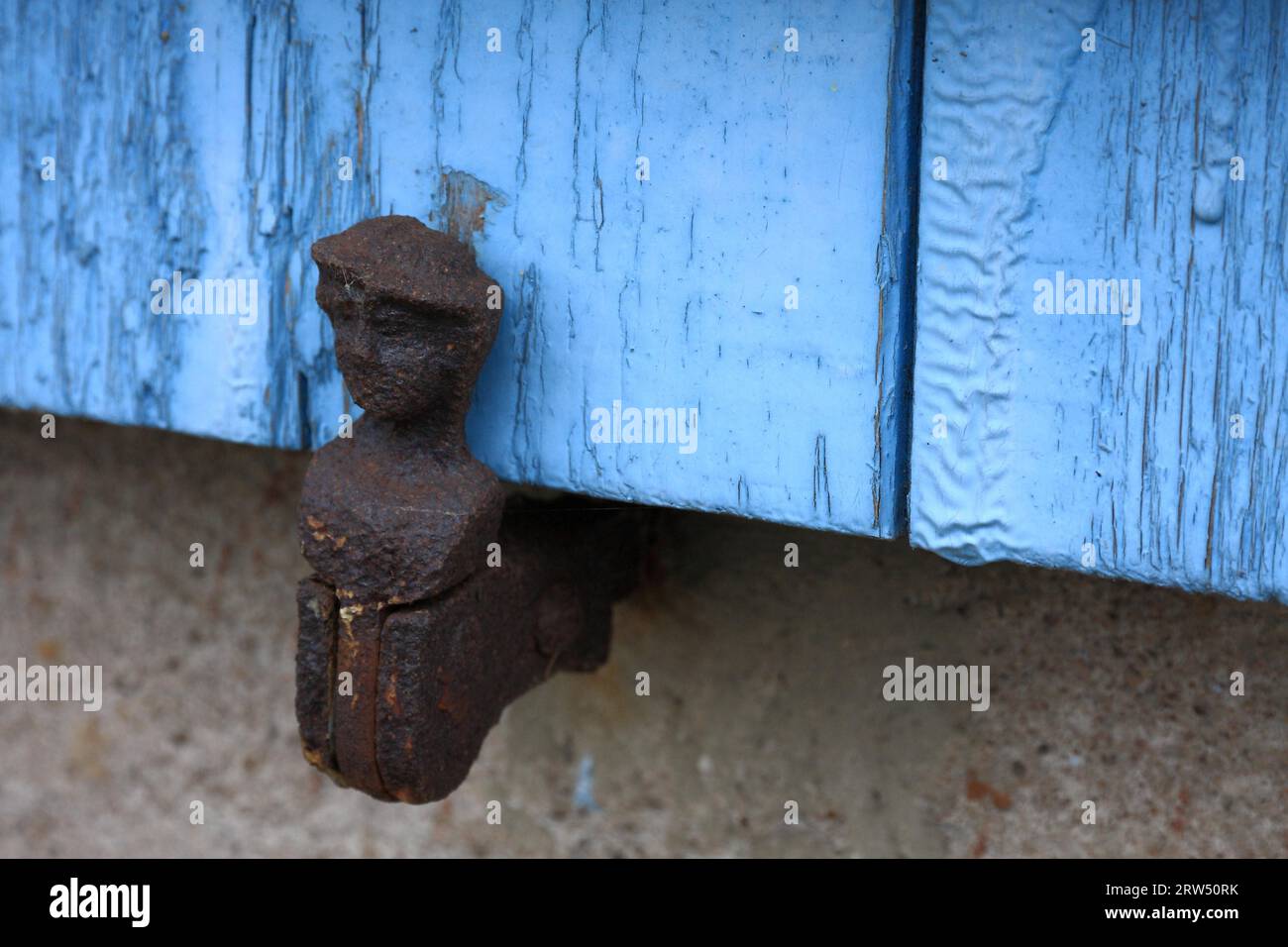 Historic bracket in the shape of a male on a shutter painted light blue ...