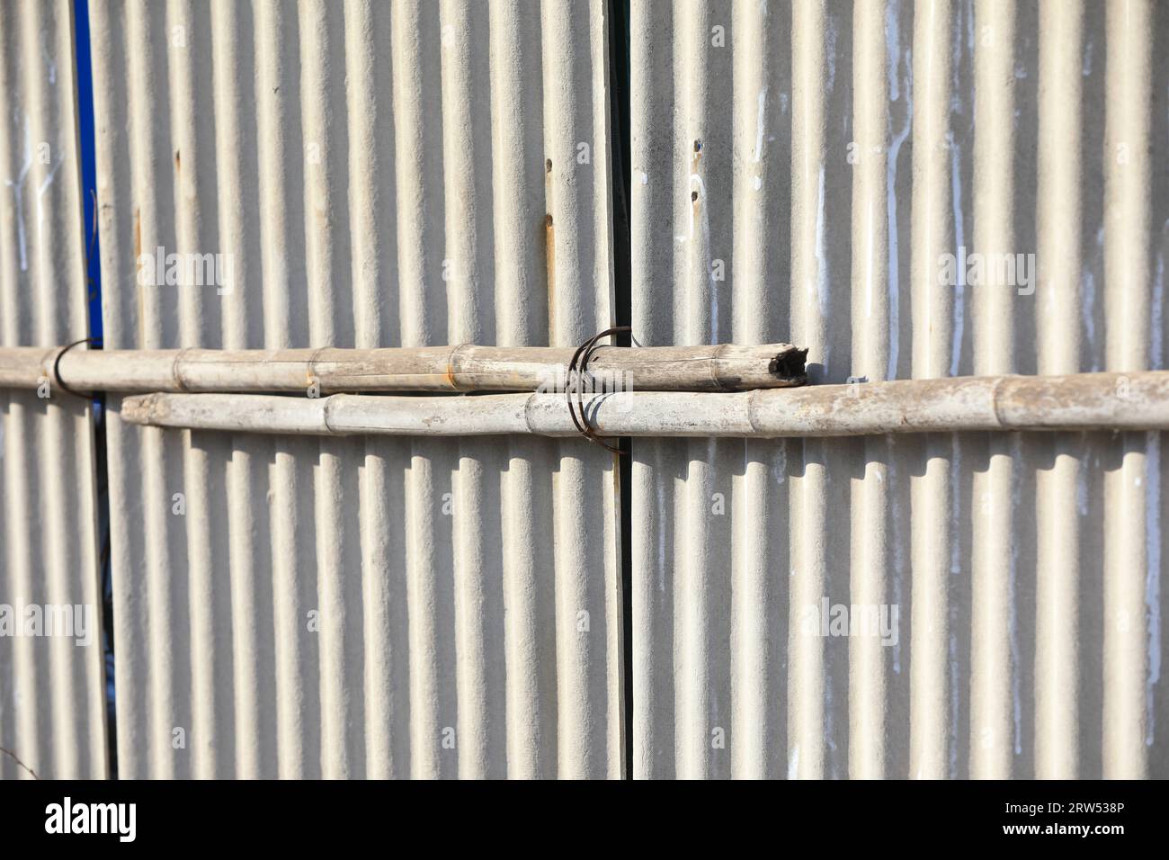 Asbestos tiles and wooden poles are bound together Stock Photo - Alamy