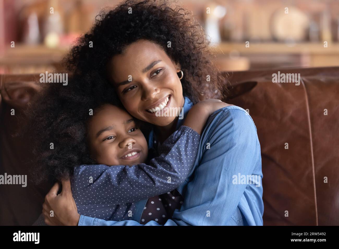 Close up smiling dreamy African American mother hugging little daughter Stock Photo - Alamy