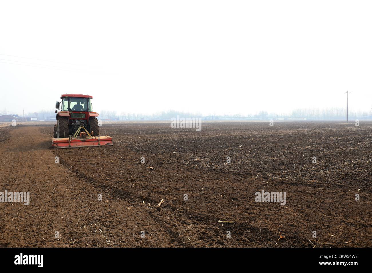 Tractor leveling land, ready to plant peas, North China Stock Photo - Alamy
