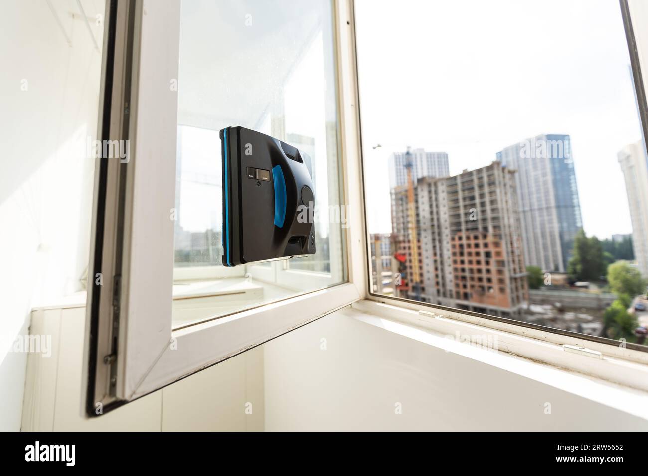 The white robotic window cleaner uses a brush and vacuum for a thorough ...