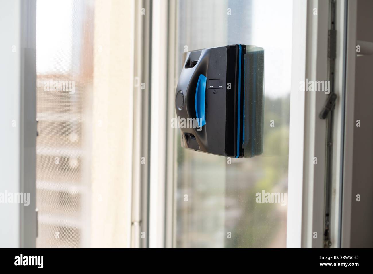 The white robotic window cleaner uses a brush and vacuum for a thorough ...