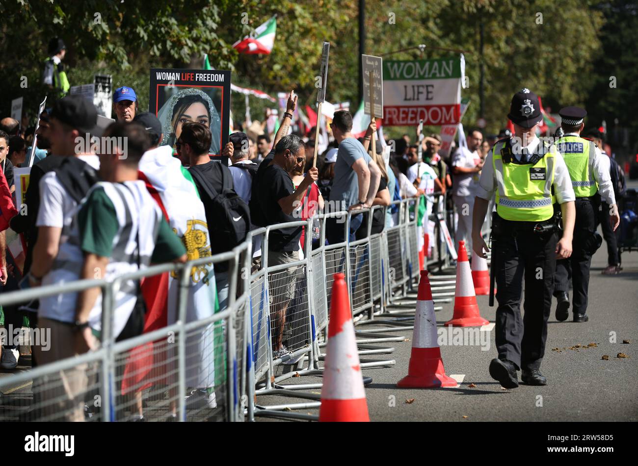 Protesters gather opposite the Iranian Embassy behind barriers with ...