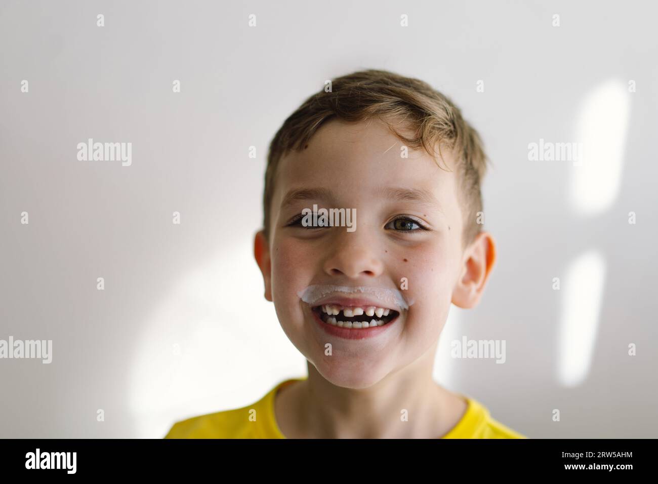 Cute boy drinks kefir or milk. Funny portrait of a boy with a milk ...