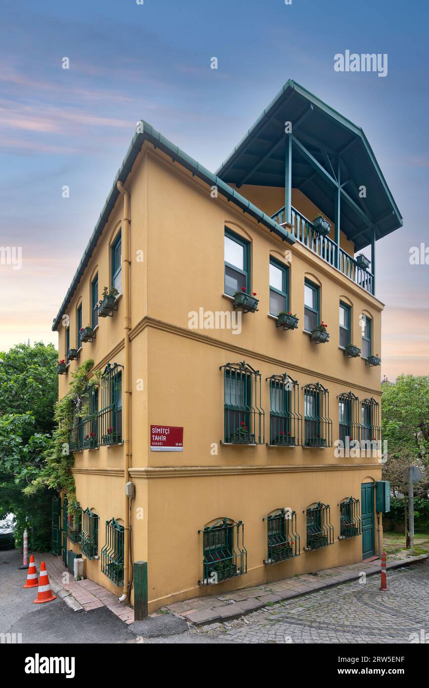 Residential building with walls painted in orange and green, with wrought iron window and ...