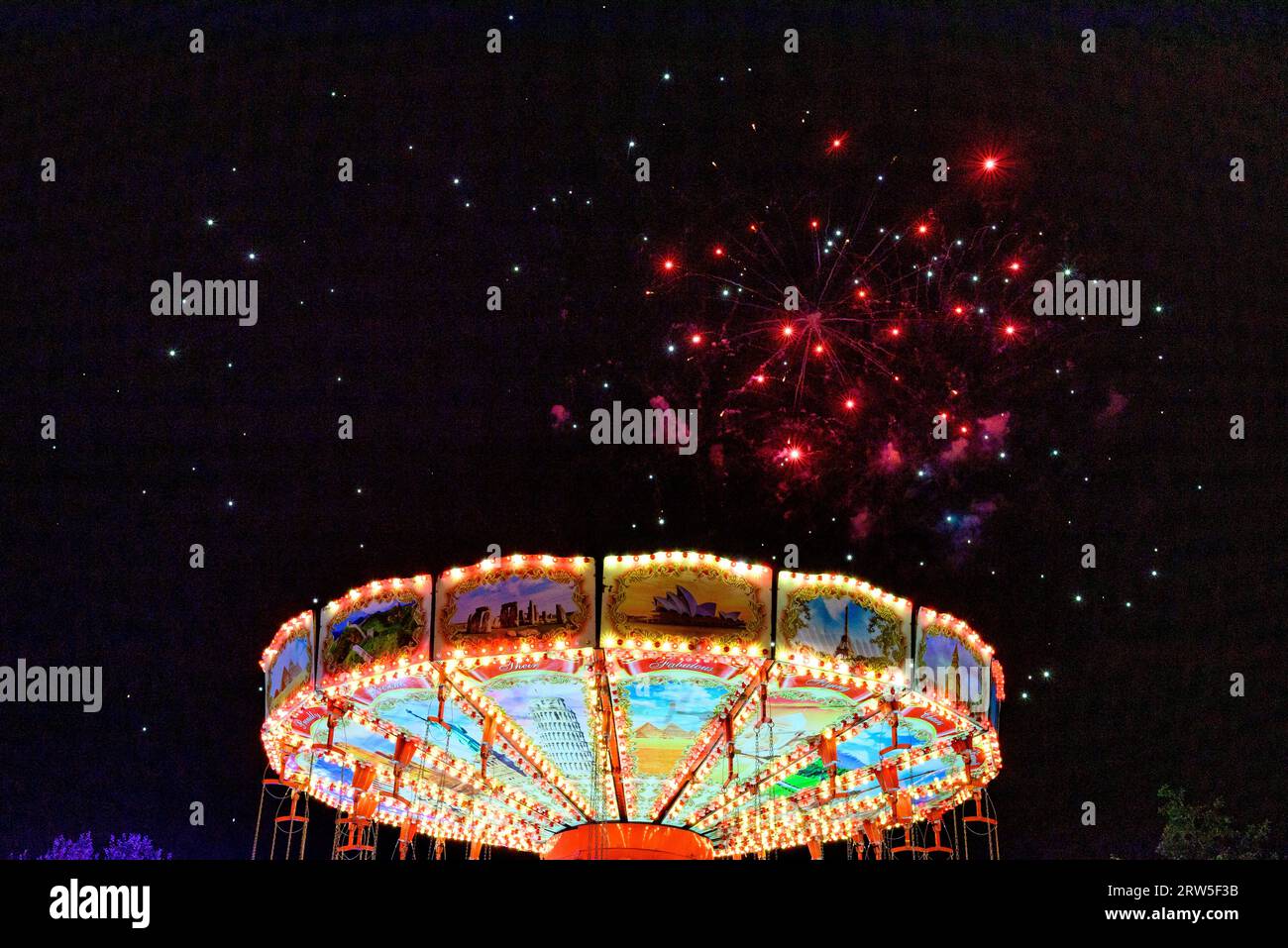Fireworks above a carousel fairground ride at a funfair at night Stock ...