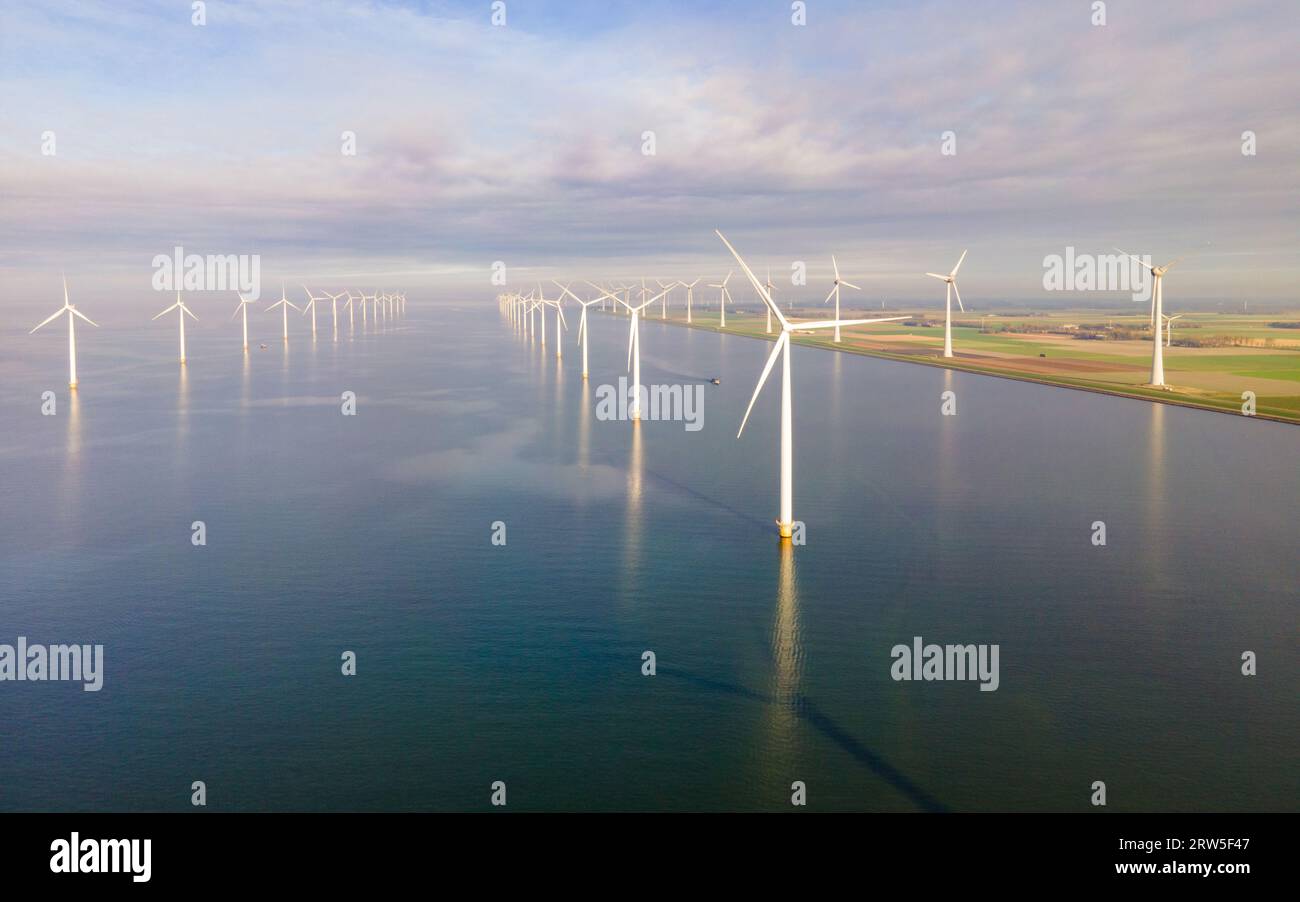 Wind turbines in a stormy sea against a gloomy gray sky. Sustainable ...
