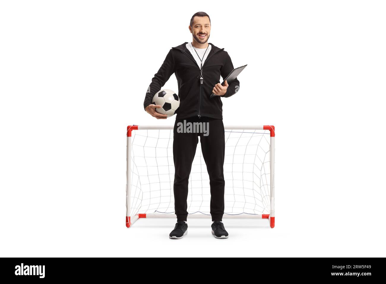 Full length portrait of a football trainer holding a ball and a ...