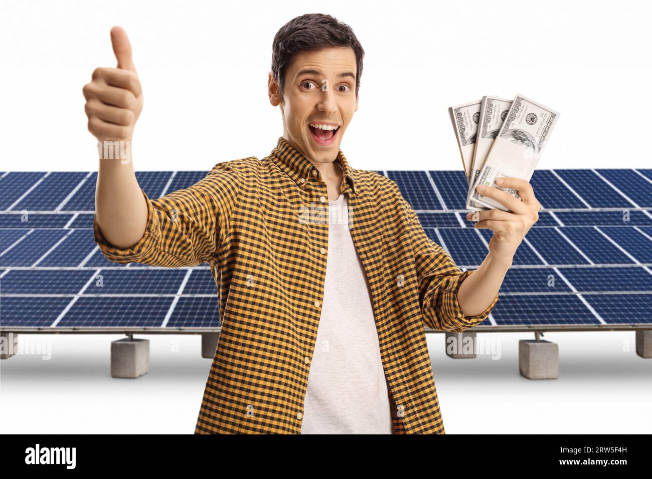 Happy young man holding stacks of money and gesturing a thumb up sign ...