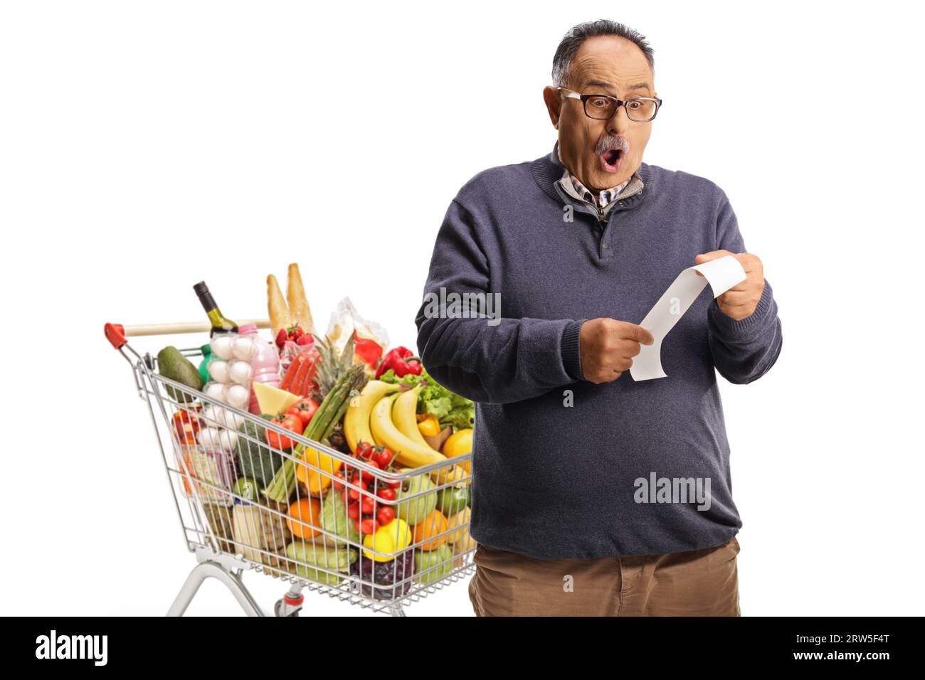 Shocked mature male customer with a shopping cart looking at a bill ...