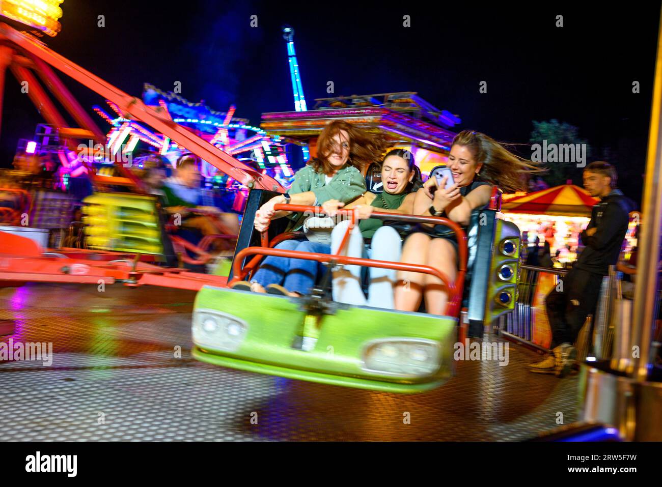 Female funfair riders spinning around at high speed, Ringwood Carnival ...