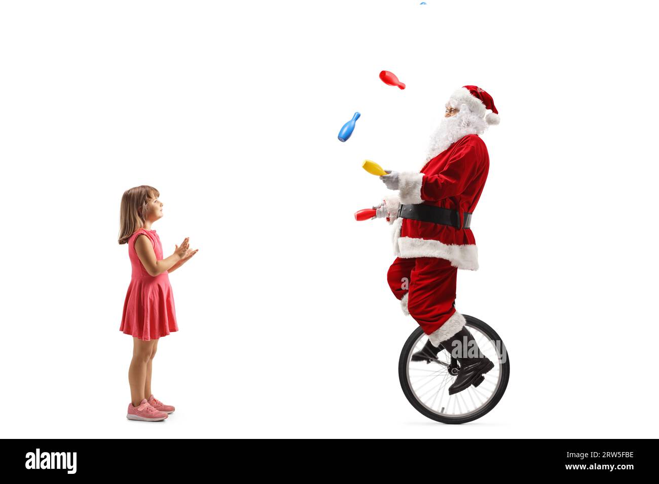 Little girl clapping and watching santa claus man riding a unicycle and ...