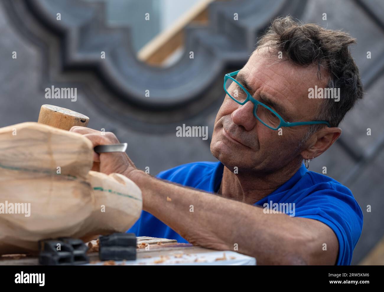 A French artisan woodworker carves a gargoyle using traditional methods ...