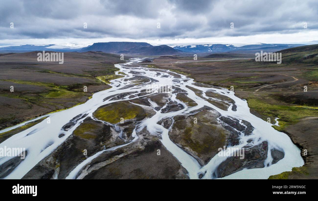 Aerial view of braided glacial river near with snow capped mountains ...