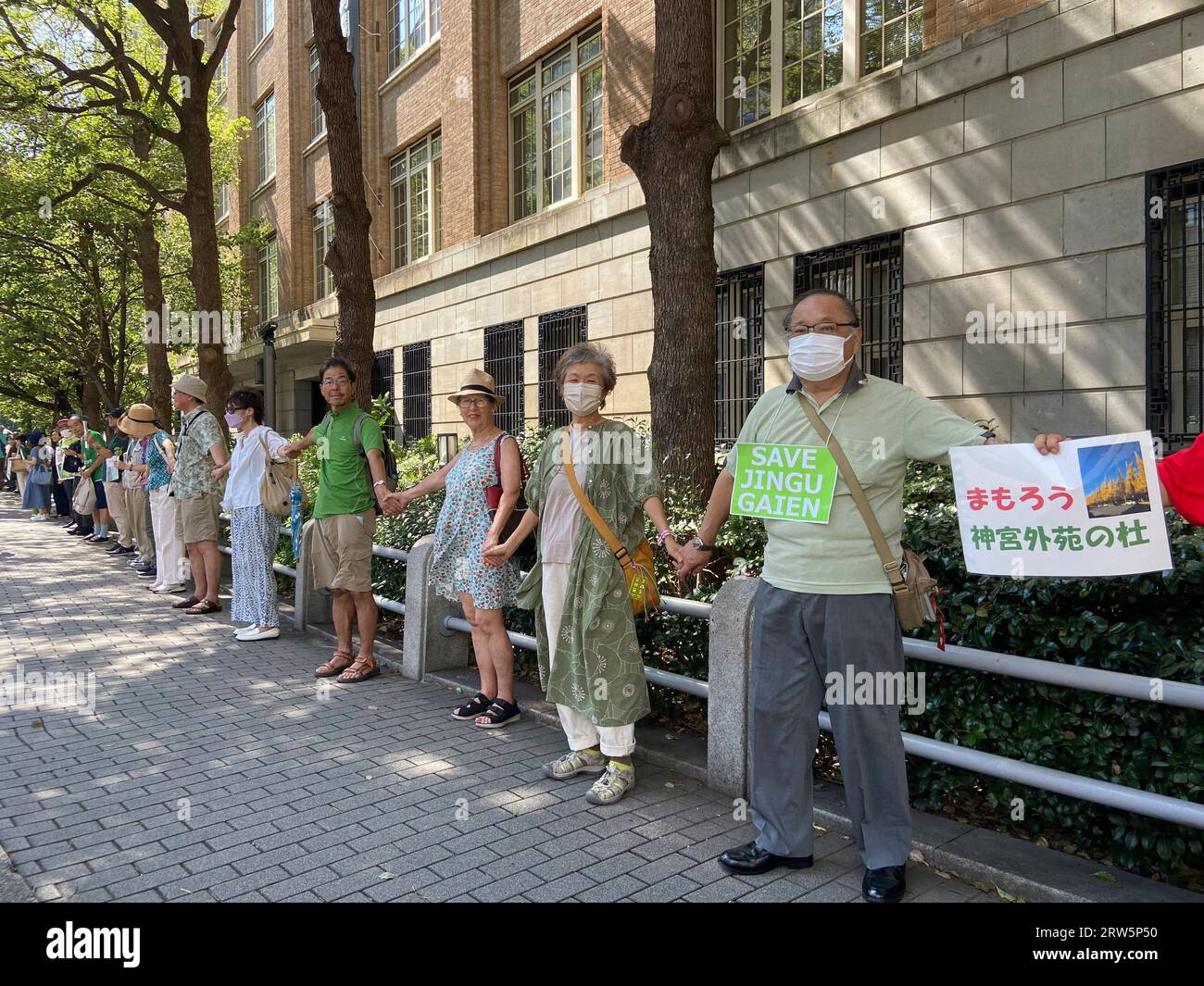 People form a human chain outside of the Ministry of Education, Culture ...