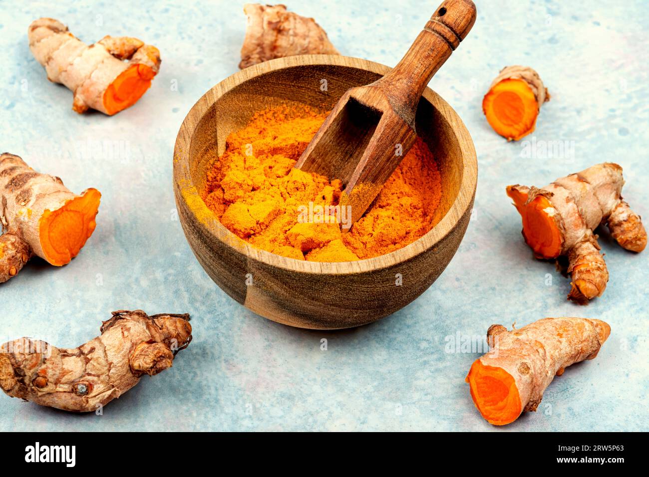 Fresh turmeric root in wooden bowl and turmeric powder. Curcuma longa ...