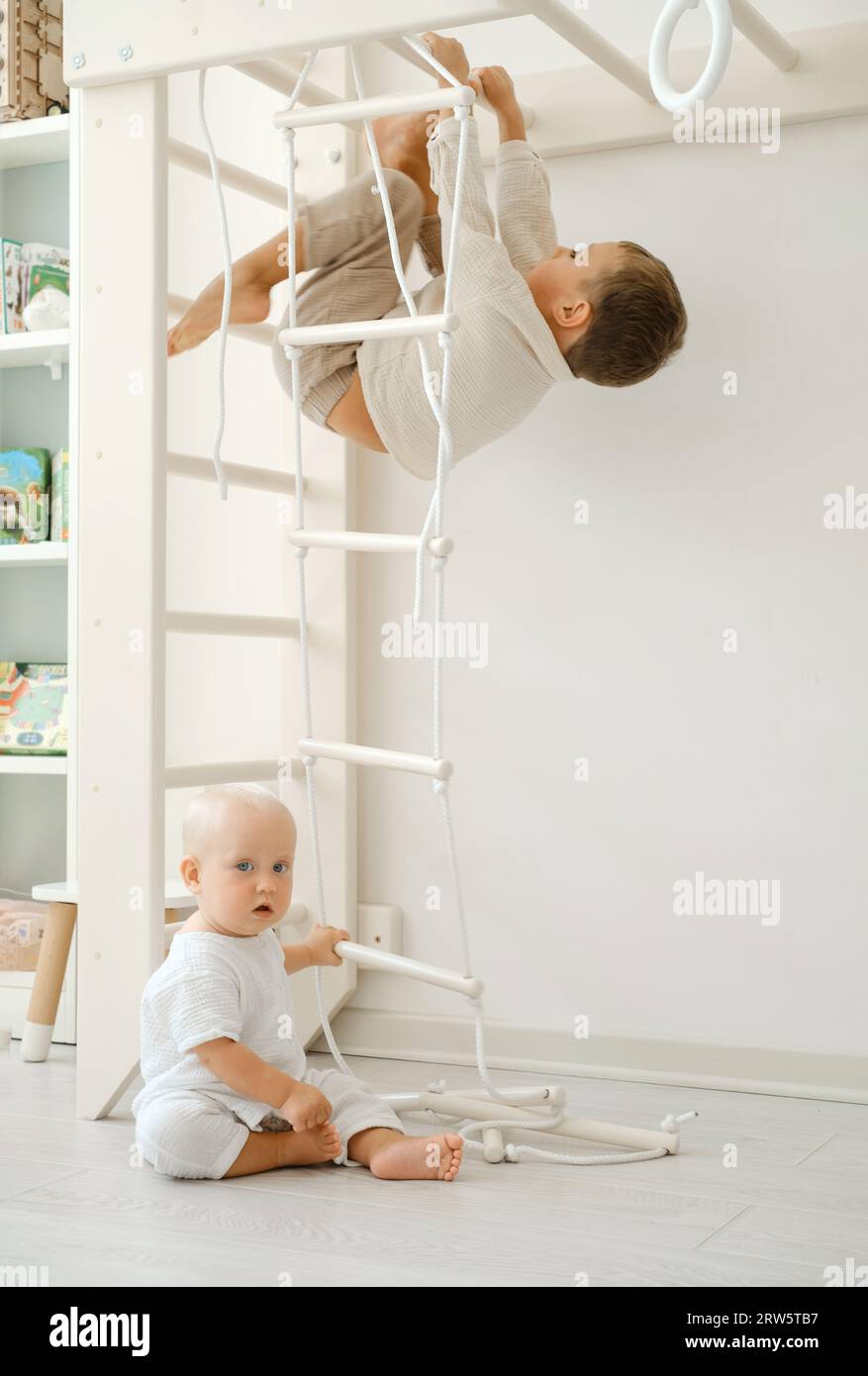 Children are exercising on Toddler Indoor Gym Playset. Kid climbing the ...