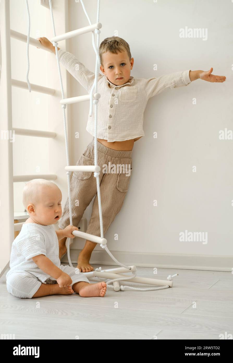Children are exercising on Toddler Indoor Gym Playset. Kid climbing the ...