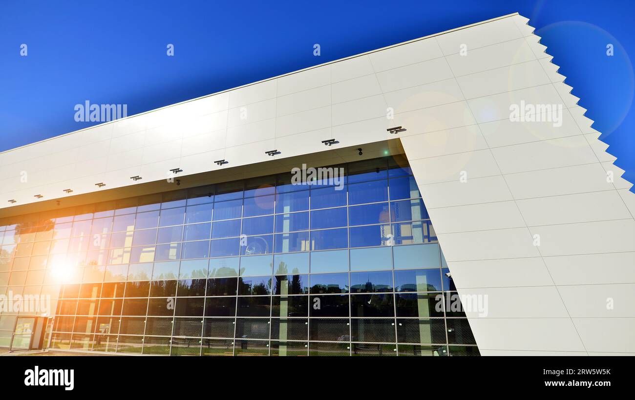 Minimalist photo of an exterior of a modern tin building with big glass ...