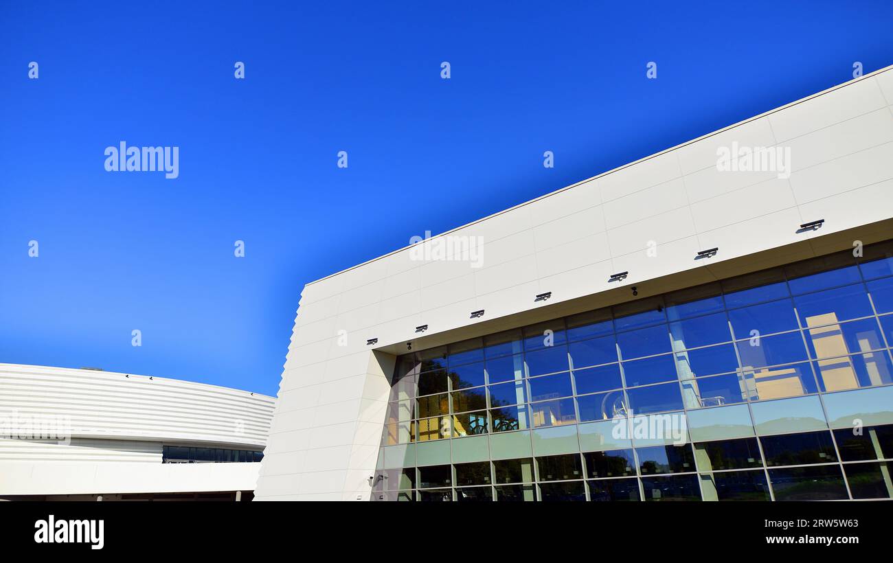 Minimalist photo of an exterior of a modern tin building with big glass ...
