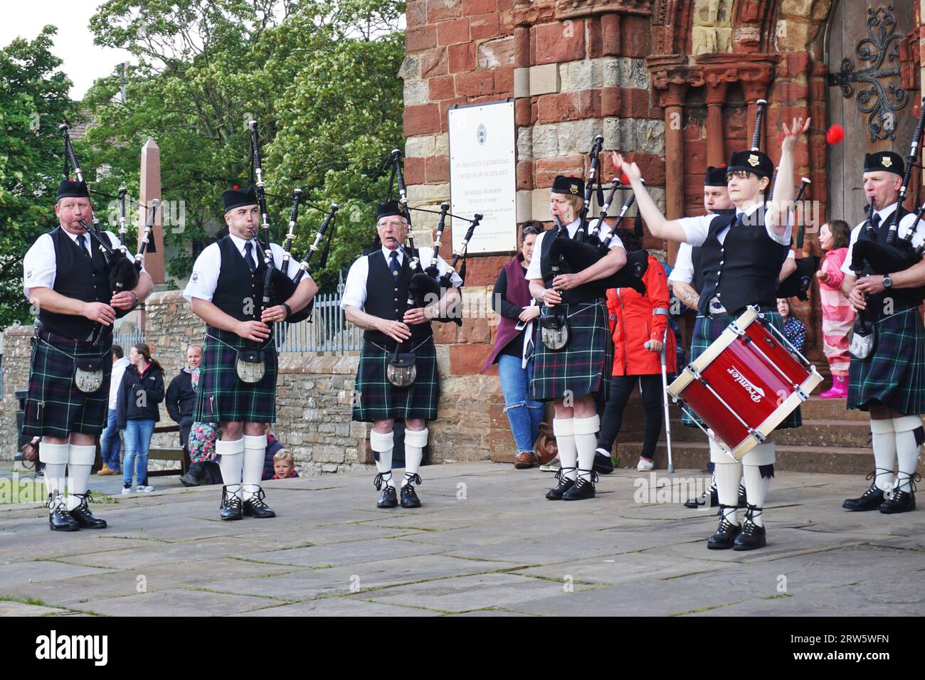 The drummer spins her drumsticks with a flourish as members of the ...