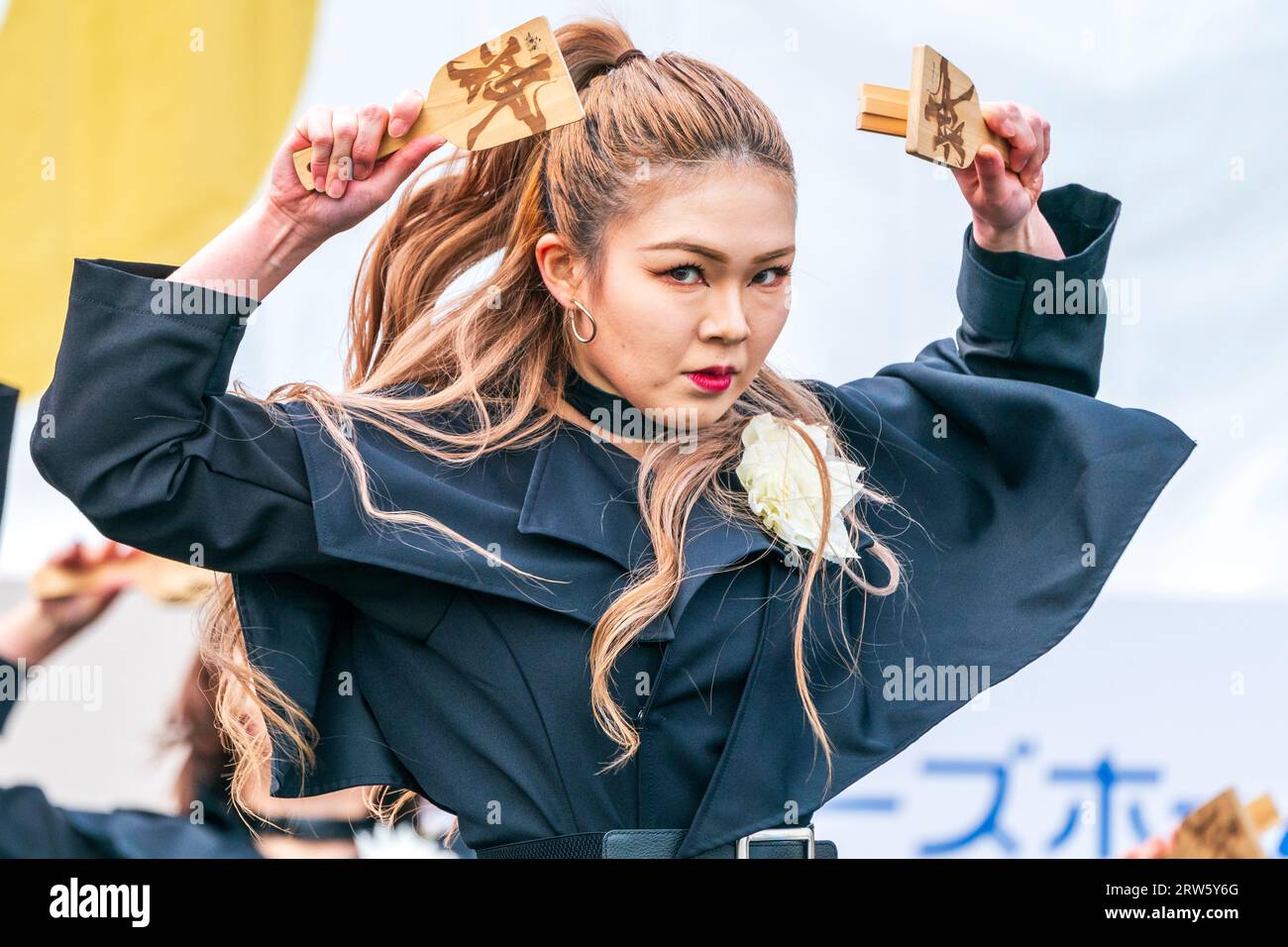 Japanese young woman, with long brown hair, holding naruko, wooden ...