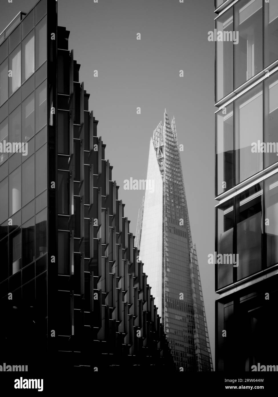 A vertical grayscale view of the Shard tower in London surrounded by ...