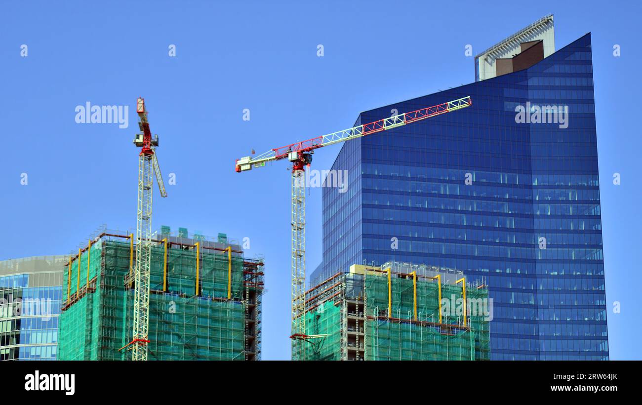 Modern high-rise buildings under construction next to glass skyscrapers ...