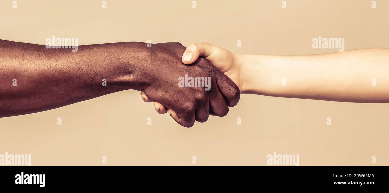 African and caucasian hands. Giving a helping hand to another. Woman ...