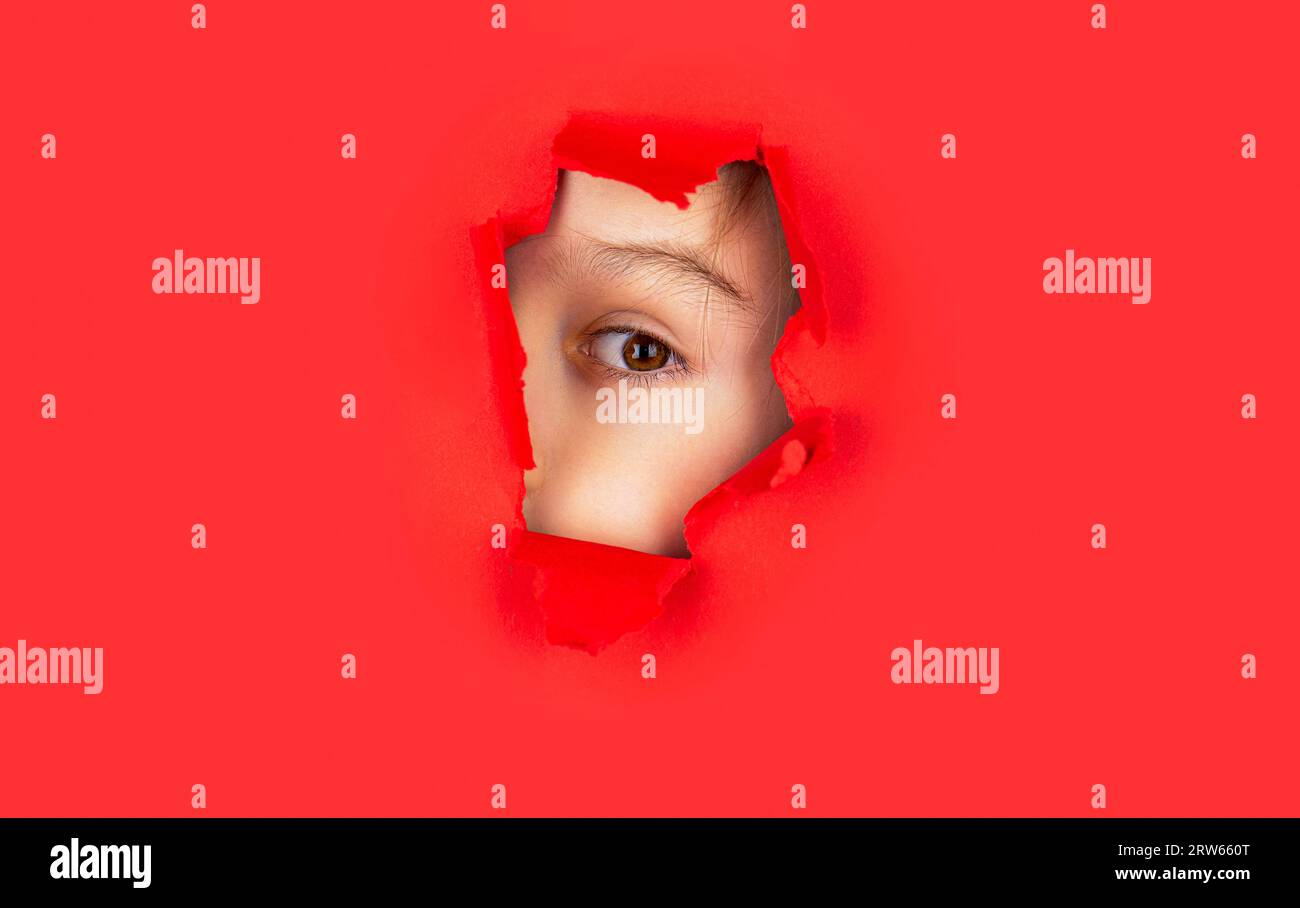 Through paper. Little boy looking through paper. Spy eye watching ...