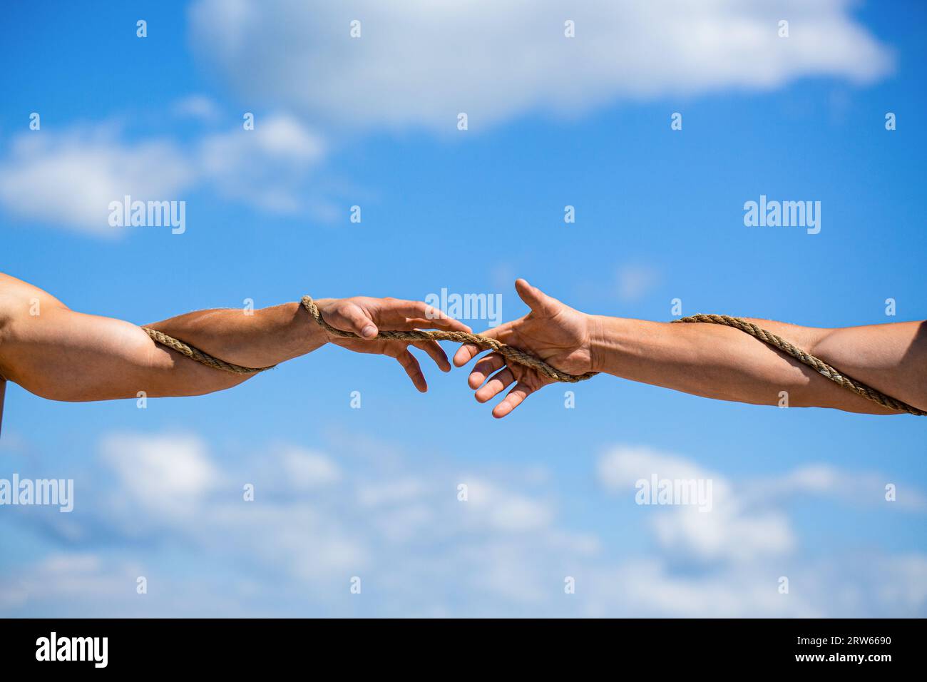 Hand holding a rope, climbing rope, strength and determination. Rescue, help, helping gesture or ...