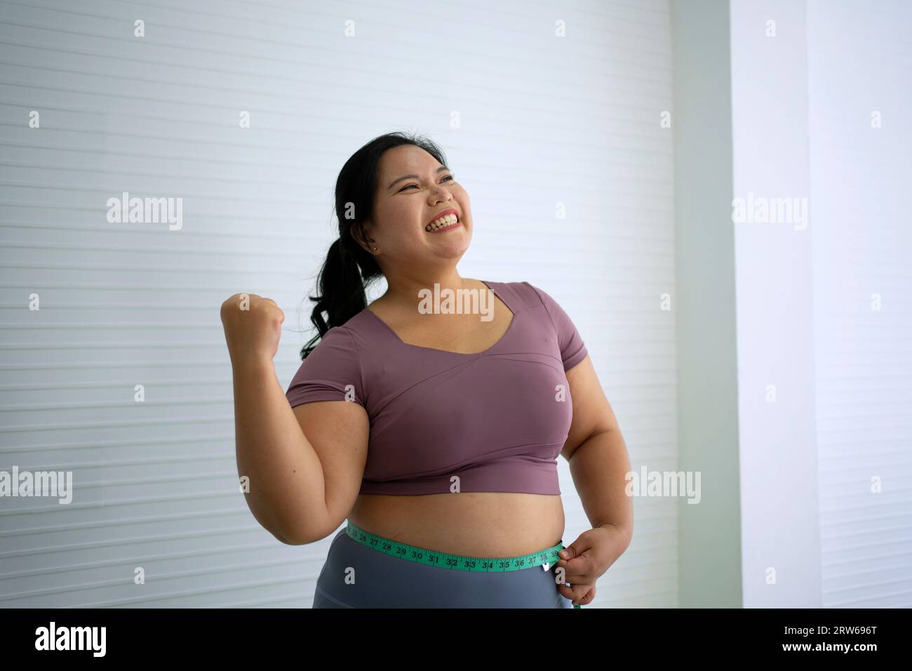 Plus size woman is measure her waist after exercise. Health care and ...