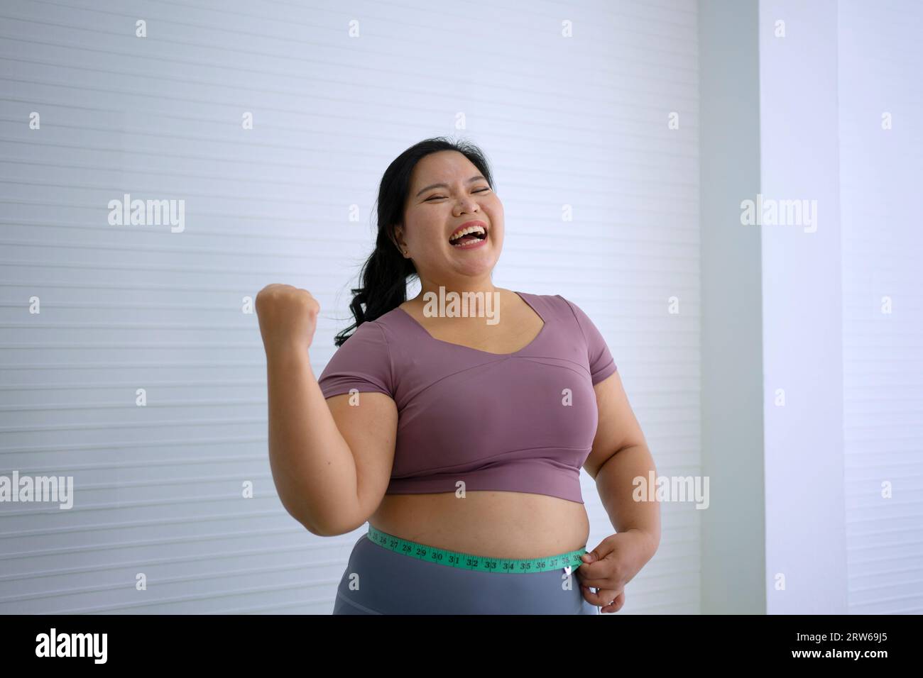 Plus size woman is measure her waist after exercise. Health care and ...