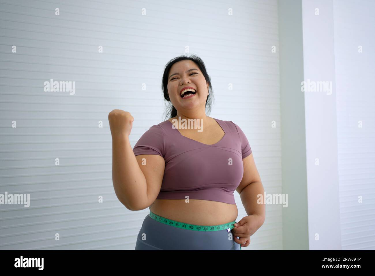 Plus size woman is measure her waist after exercise. Health care and ...