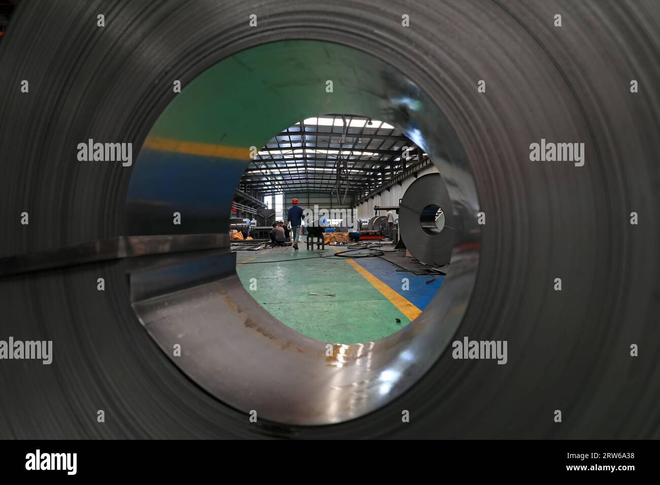 Workers work hard on the strip steel production line in the factory ...