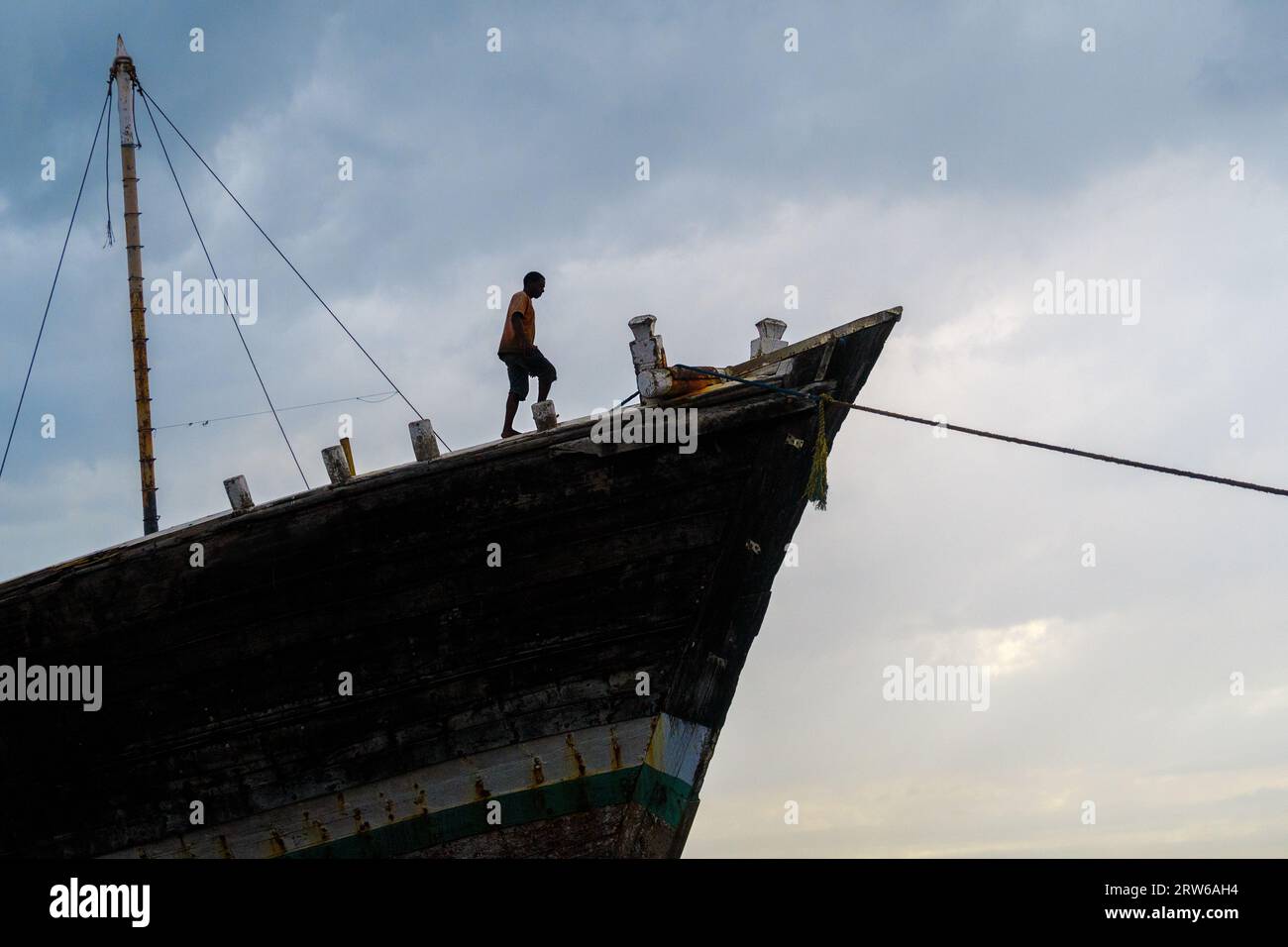 dramatic silhouette of a man standing on the bow of a ship Stock Photo ...