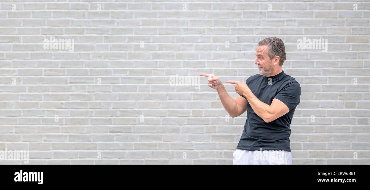 Promotional photo of an attractive friendly man pointing to the left ...