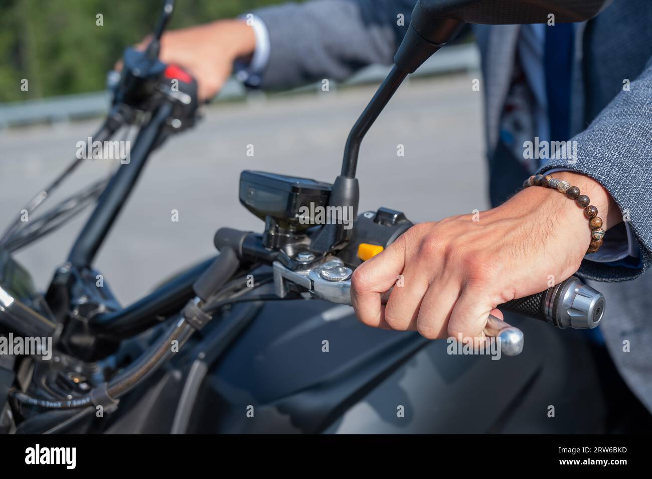 Caucasian man rides an electric motorcycle. Close-up of a man's hand ...