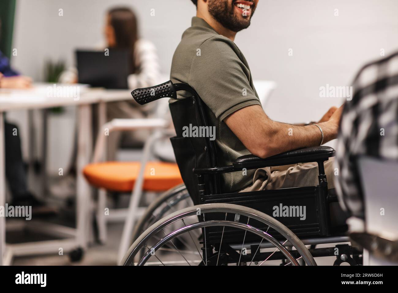 Happy, smiley, positive man in wheelchair at office, discussing ...