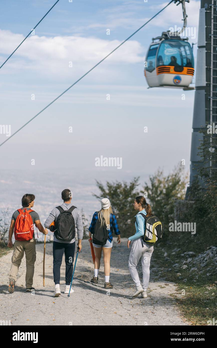 A back view photo of two couples walking on a small street in the ...