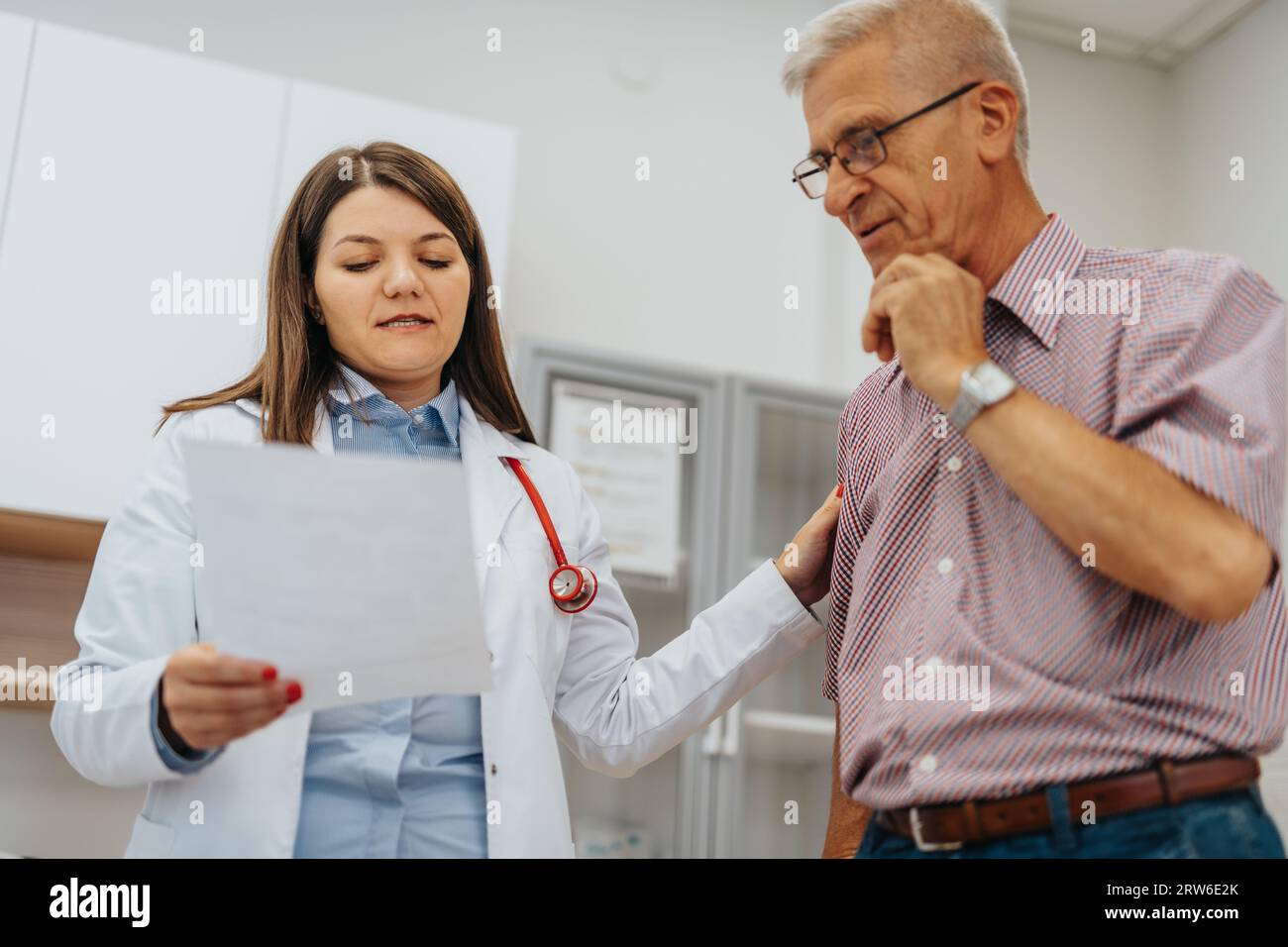 In a clinical office, a doctor analyzes an x-ray film to diagnose and ...