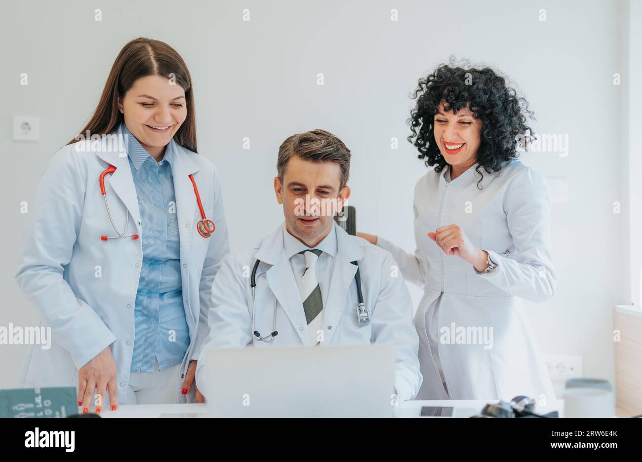 A doctor reviews test results with his nurses for a patient on a health ...