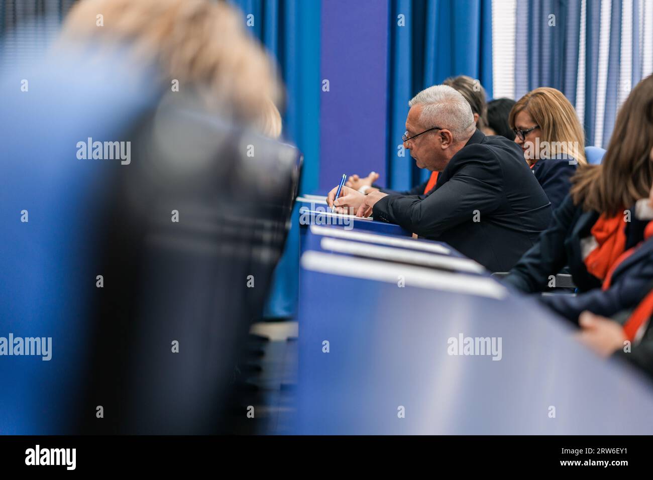 A diverse group of professionals attending a conference, collaborating ...