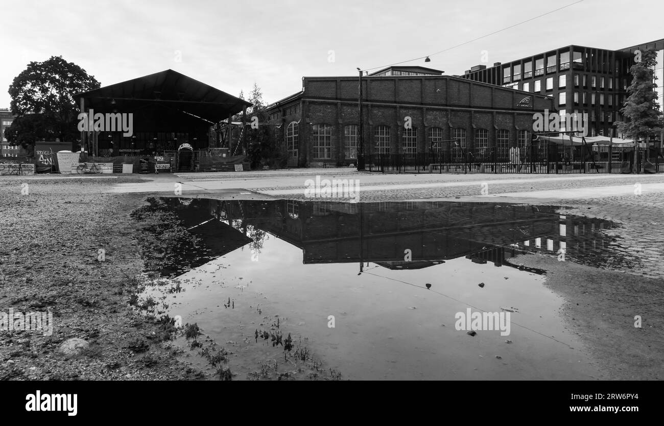 Train factory buildings with reflection on a puddle Stock Photo - Alamy