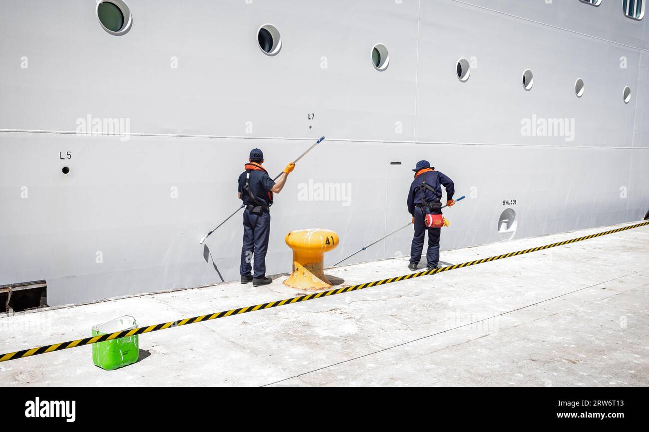 Two crewmen painting exterior of P&O Cruise ship Arvia in port at ...
